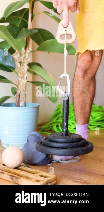 vertical shot. rock climber male hand holds strength training board ...