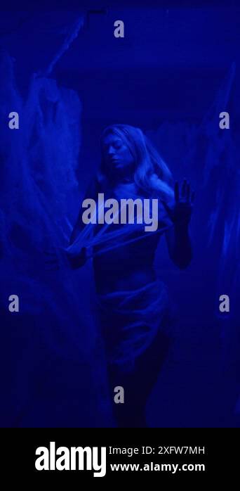 Vampire woman tries to free herself from thick cobwebs in a dark ...