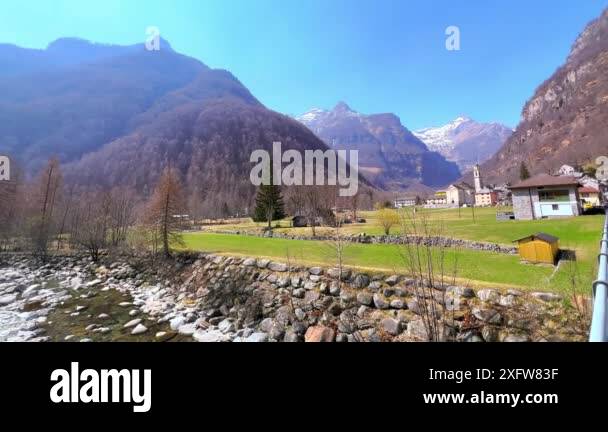 Panorama with scenic green pasture in front of Sonogno village, tops of ...