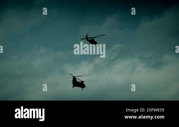 Two military helicopters conduct aviation maneuvers in the sky with ...