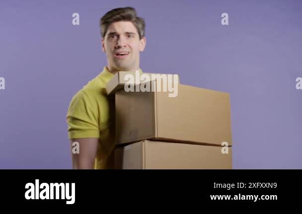 Young 30s man carrying heavy parcel box, overall load. Guy with address ...