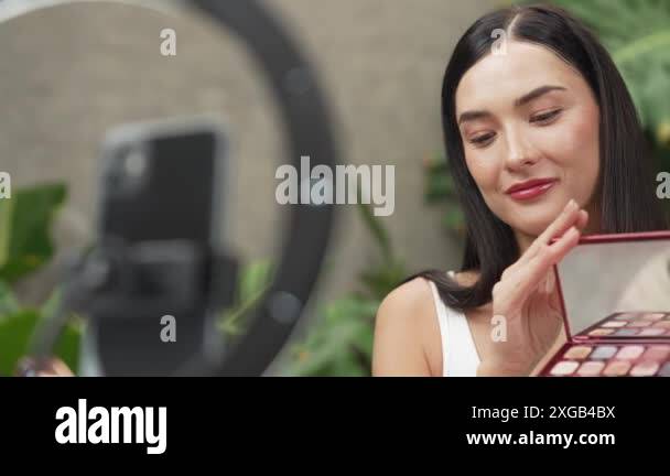 Beautiful content creator making natural beauty and cosmetic tutorial at green plant leave ...