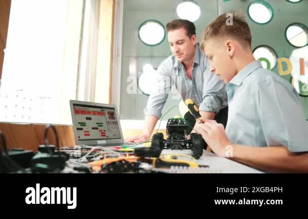 Caucasian teacher pointing at laptop screen and giving advise for programming system or coding ...