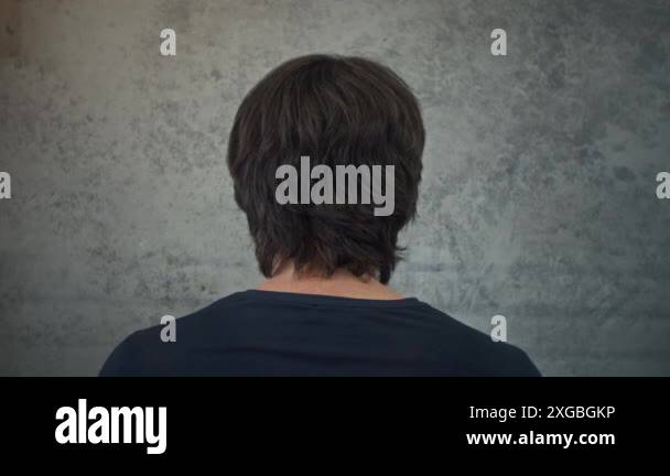 Back view of man turning head while posing before getting his hair cut ...