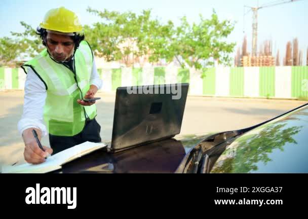 Construction worker wearing yellow hard hat and reflective vest using ...