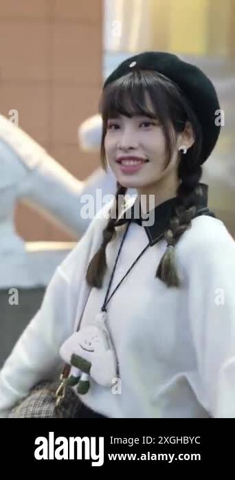 Vertical video of a young and cute Taiwanese woman in her 20s walking ...