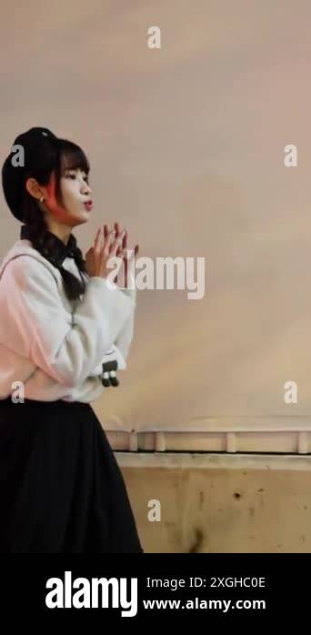 Vertical video of a young and cute Taiwanese woman in her 20s walking ...