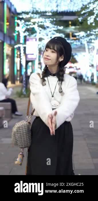 Vertical video of a young and cute Taiwanese woman in her 20s walking ...