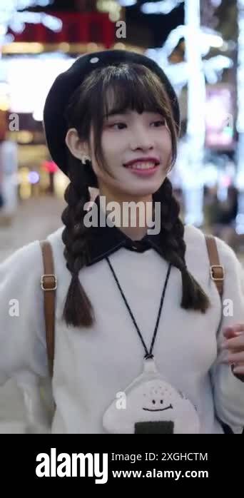 Vertical video of a young and cute Taiwanese woman in her 20s walking ...