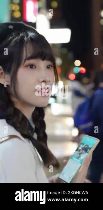 Vertical video of a young and cute Taiwanese woman in her 20s walking ...