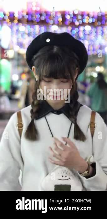 Vertical video of a young and cute Taiwanese woman in her 20s walking ...