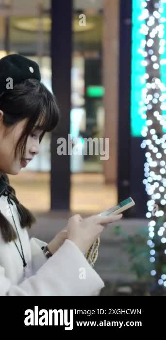 Vertical video of a young and cute Taiwanese woman in her 20s walking ...