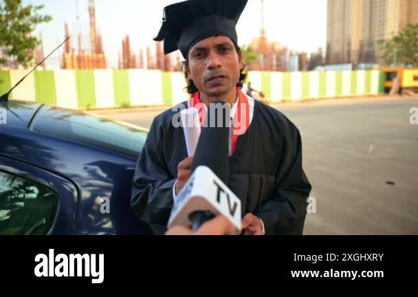 Graduate holding degree giving interview, young Indian student in a cap ...