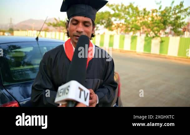 Graduate holding degree giving interview, young Indian student in a cap ...