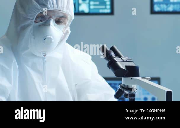 Scientist in protection suit and masks working in research lab using ...