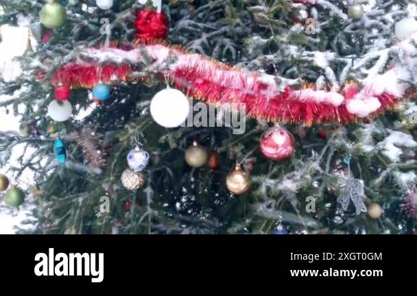 Christmas tree decorated with toys and balls on the street. It is ...