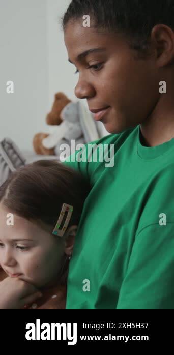 Vertical side view tilt down shot of caring young African American ...