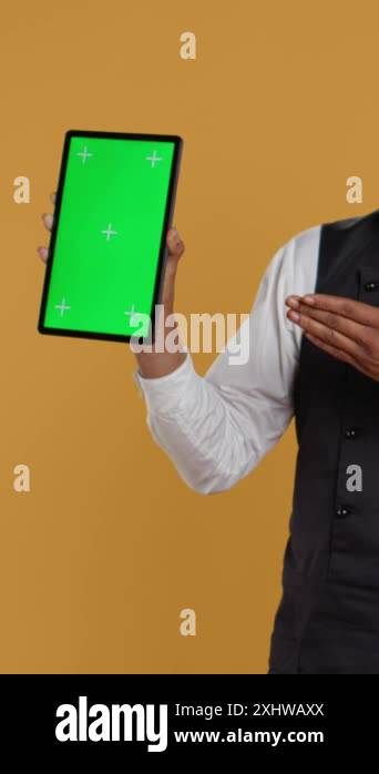 Vertical Video Restaurant waiter presenting a green screen layout on ...