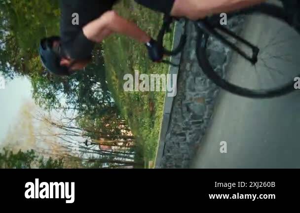 Skinny strong cyclist sprinting up the hill in green park. Male fit ...