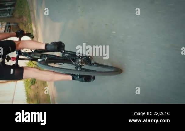 Cyclist with strong legs pedaling out of the saddle climbing the hill ...