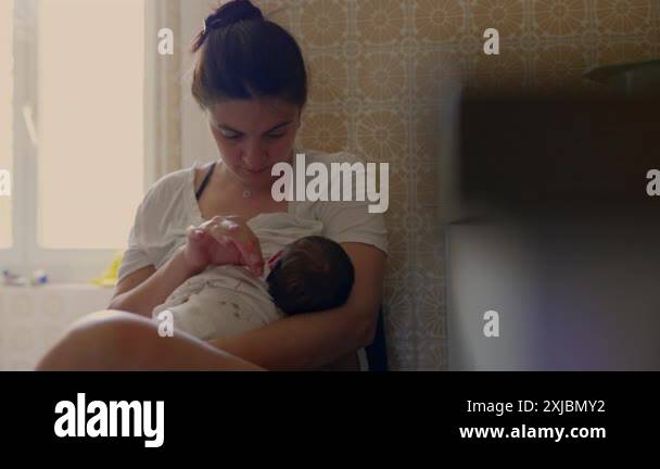 Mother breastfeeding newborn baby in kitchen, a tender moment of ...