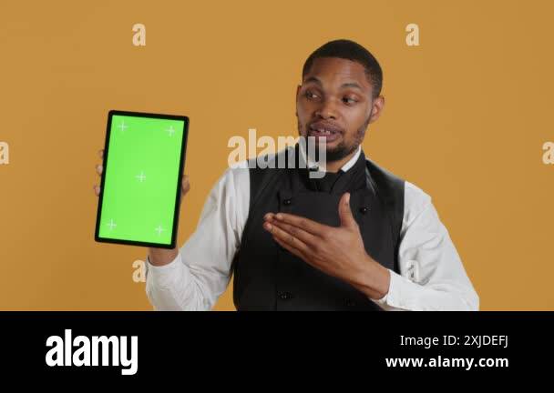 Restaurant waiter presenting a green screen layout on tablet against ...