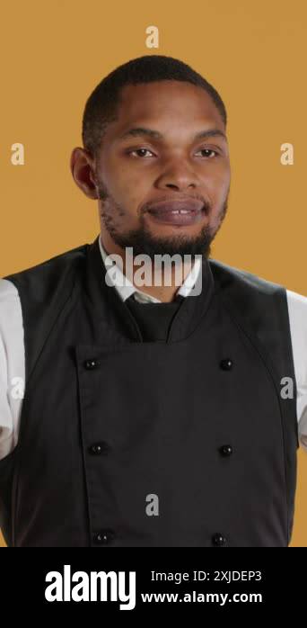 Vertical Video Waiter flexing his muscles and showing his strength in ...