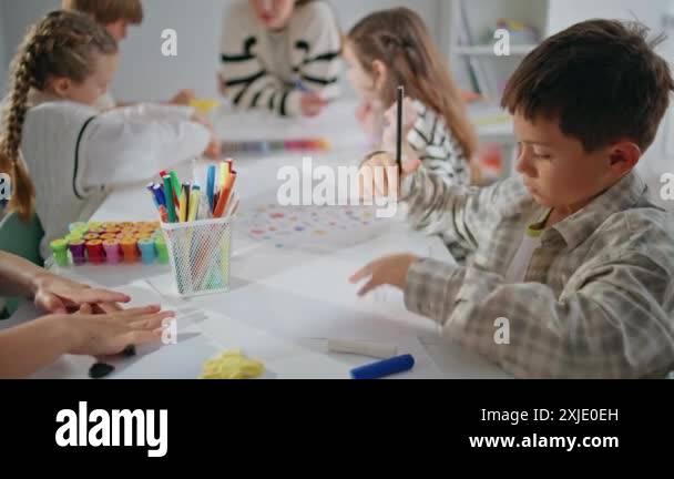 Group children drawing pictures at big table closeup. Inspired kids ...