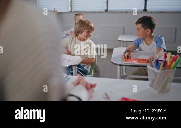 Curious kids enjoying lesson at cozy class room. Closeup unrecognizable ...
