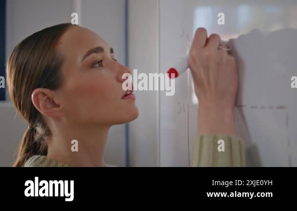 Focused educator writing board solving equation at cabinet closeup ...