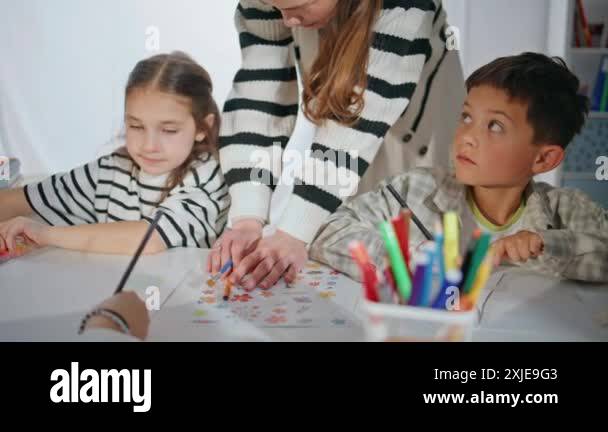 Little painters creating masterpiece with teacher in art workshop ...