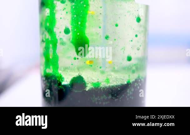Green liquid boiling in glass flask. Environmental pollution. Water ...