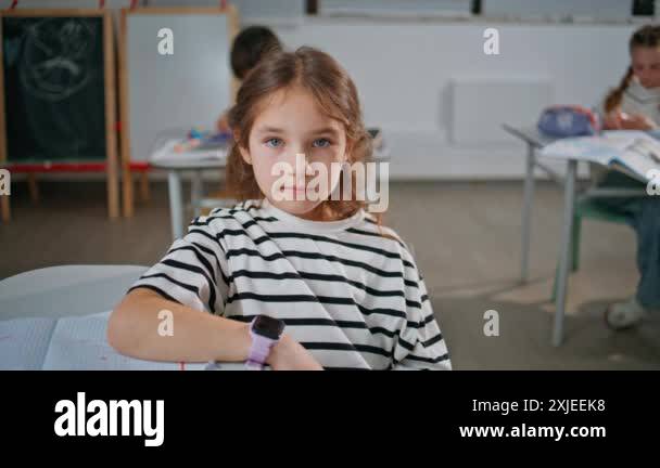 Portrait serious pupil girl looking camera at school. Calm smart kid ...