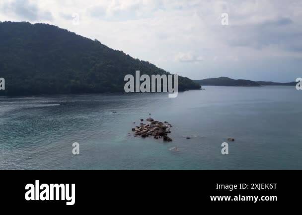 Boats are anchored in the turquoise blue water off the coast of a ...