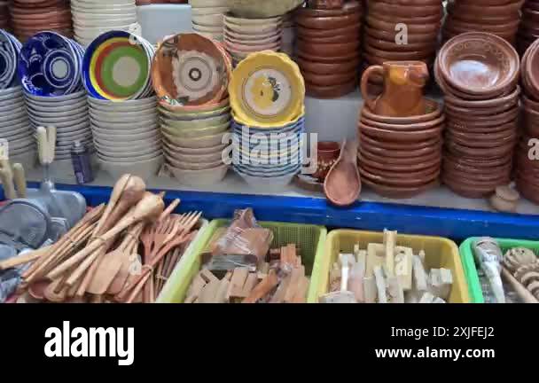 A display of traditional Mexican pottery and utensils, including plates ...