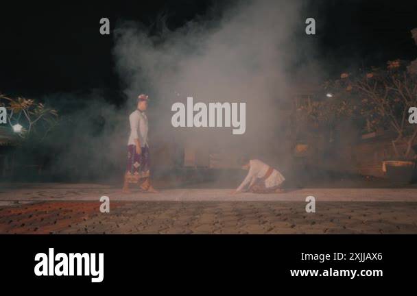 Two people in traditional attire performing a ritual or dance in a ...