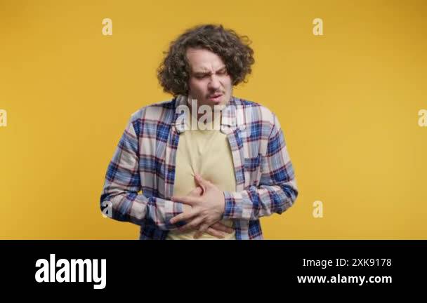 Man squeezing belly with hands because of abdominal pain. Adult guy ...