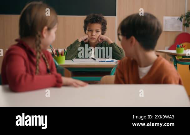 Two Caucasian children school lesson girl boy classmates laughing talk ...