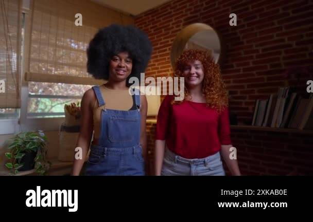 Two Gen Z women dancing and laughing together indoors, enjoying a fun ...