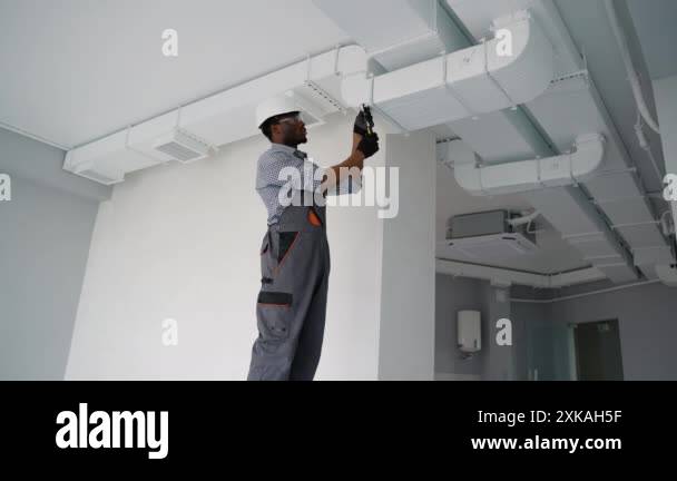 African american worker install ducted pipe system for ventilation and ...