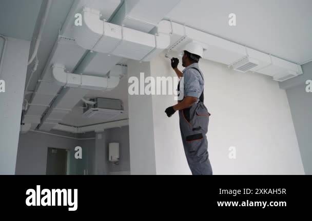 African american worker install ducted pipe system for ventilation and ...