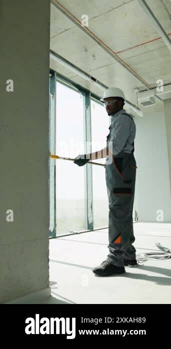 African american painter painting a wall in office. African american ...