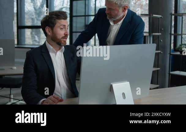 Successful excited Caucasian businessmen workers looking computer ...