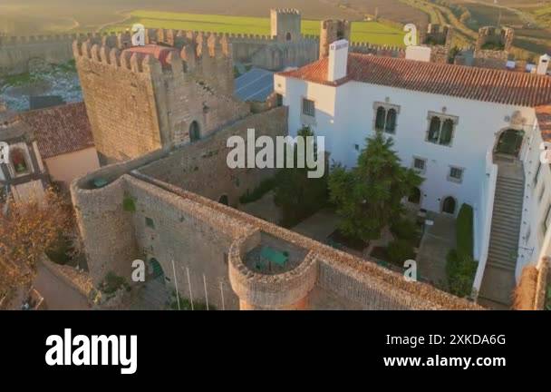 Monumental stone castle towering over small town drone view. Medieval ...
