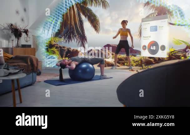 Female athlete trains with fitball. VR screen shows virtual coach and ...