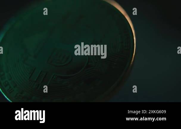 Close up of golden bitcoin coin spinning on the blue background ...