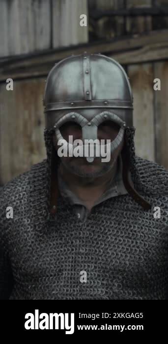 Vertical full zoom-out portrait of fierce male warrior clad in ...