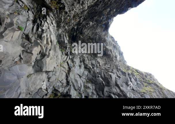 Basalt columns and sea cave with irregular shapes. Volcanic sand, Vik ...