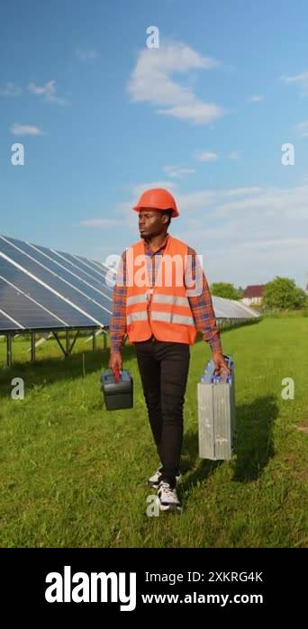 African engineer walking and inspecting construction of solar cell ...