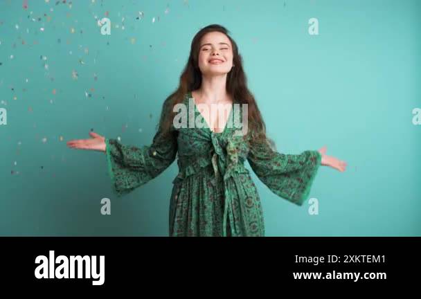 Excited young female in green dress with brown hair dancing under ...